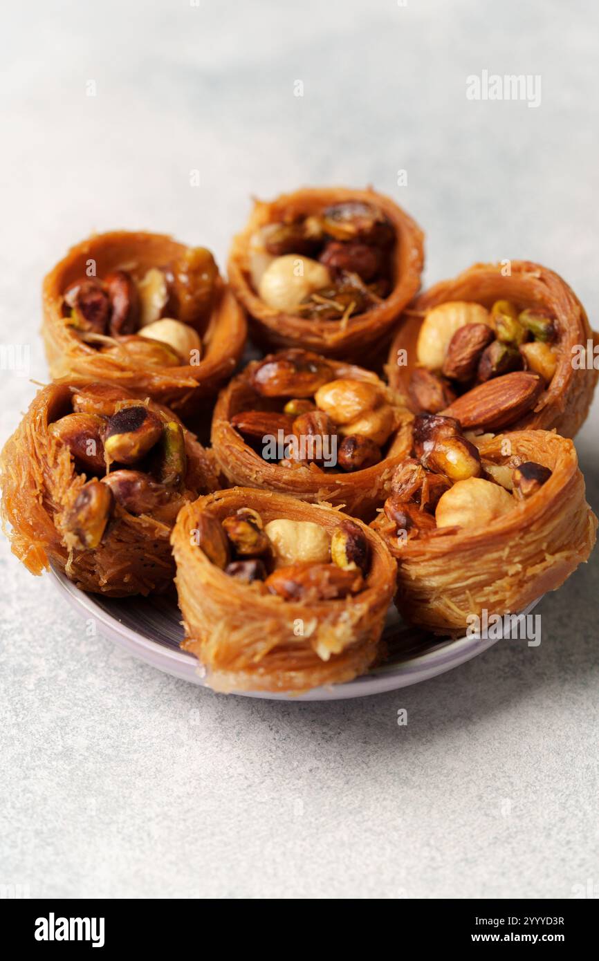 Traditional sweet pastries filled with nuts served on a plate in a cozy ...