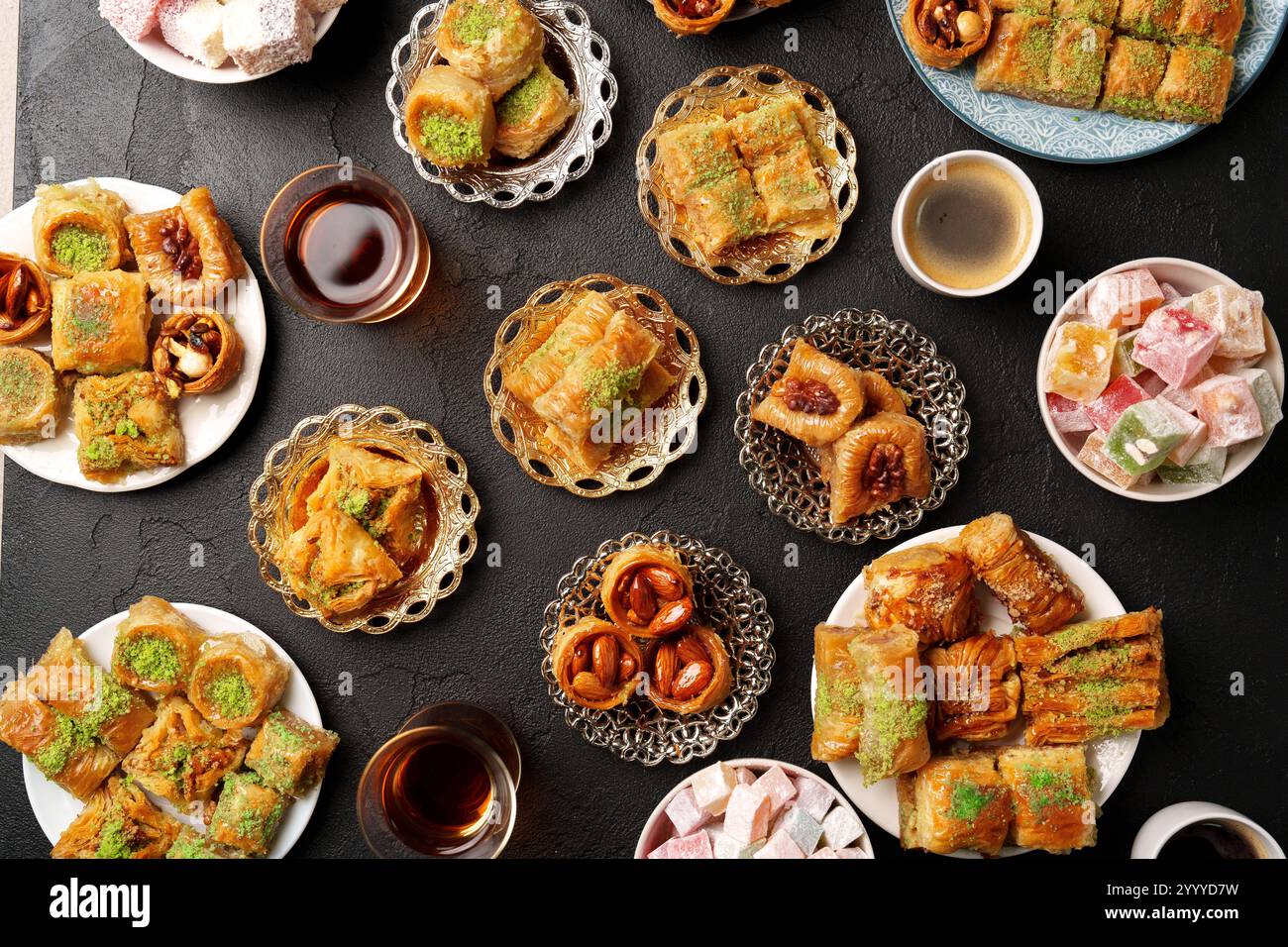 Traditional Middle Eastern sweets served on various plates with drinks ...