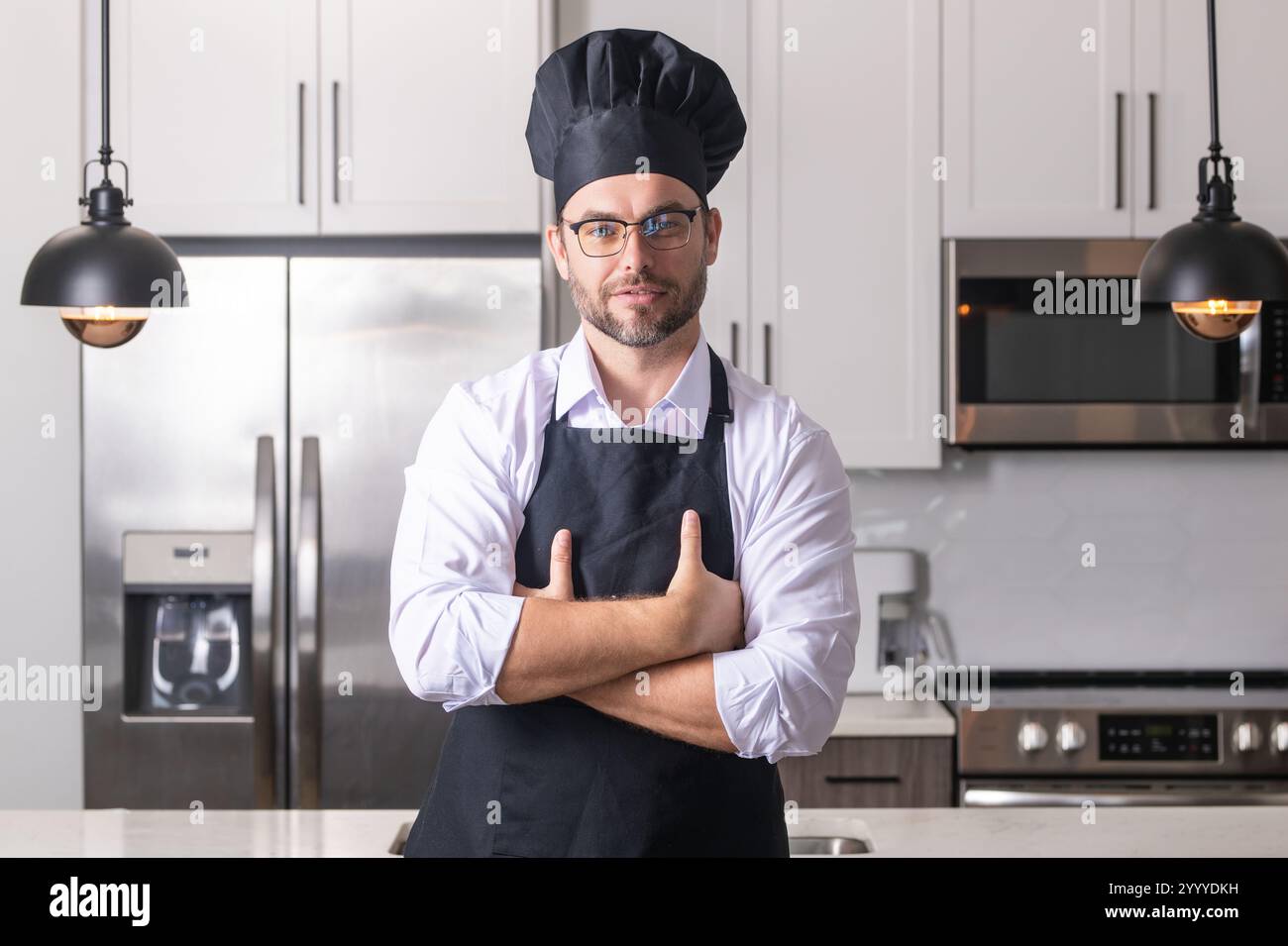Handsome man chef in uniform cooking in the kitchen. Restaurant menu ...