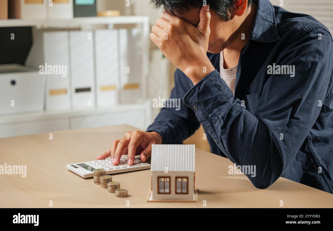 Worried individual calculates taxes at a desk, surrounded by coins and ...