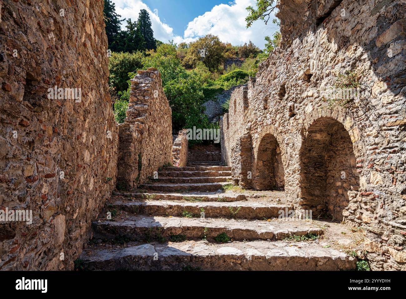 An ancient stone stairway flanked by arched walls in the ruins of ...