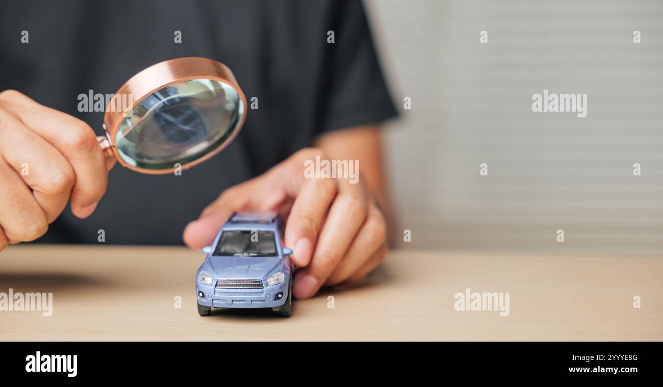 Close-up of a toy car under a magnifying glass. Depicts car repair ...