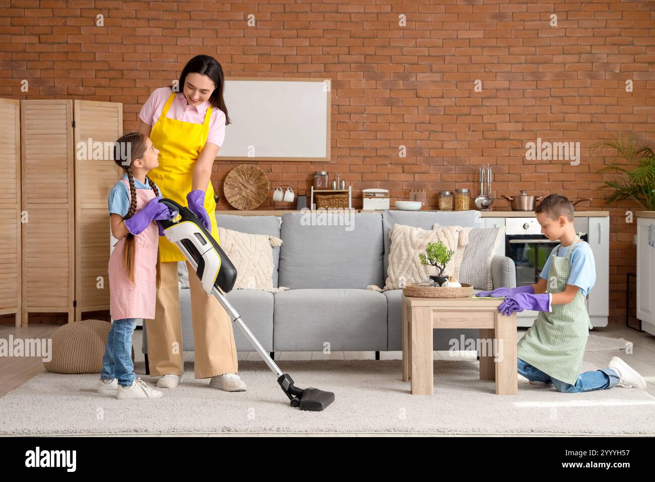 Cute little children helping their mother with cleaning routine at home ...