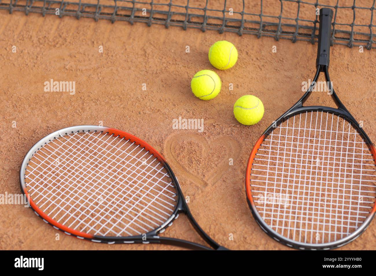 Tennis rackets, balls and heart inscribed on court floor, closeup Stock ...