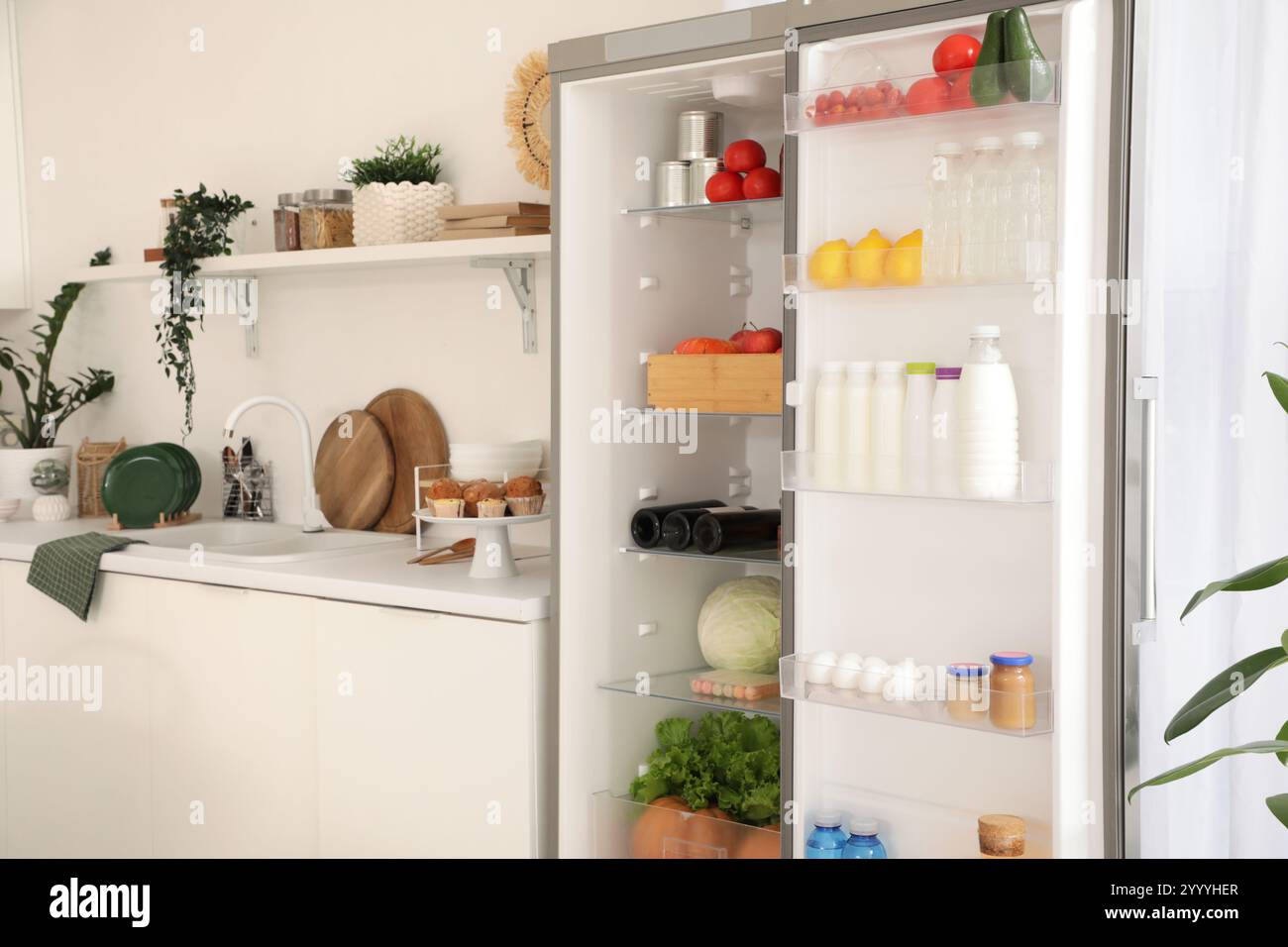 Open fridge full of different food in light kitchen Stock Photo - Alamy