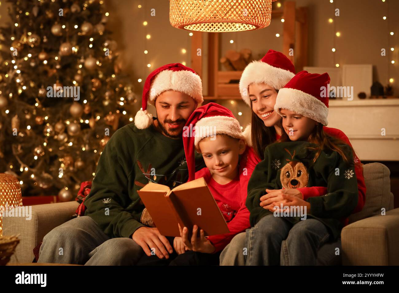 Happy family reading Christmas story at home in evening Stock Photo - Alamy