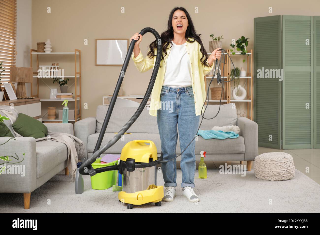 Irritated young woman with vacuum cleaner screaming at home. Stress ...