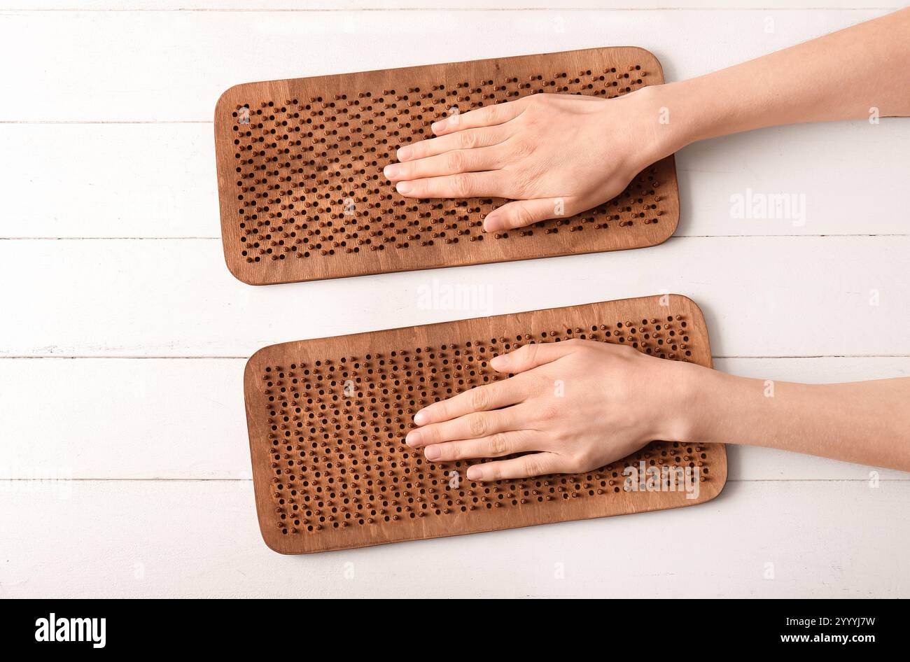 Female hands with Sadhu boards on white wooden background Stock Photo ...
