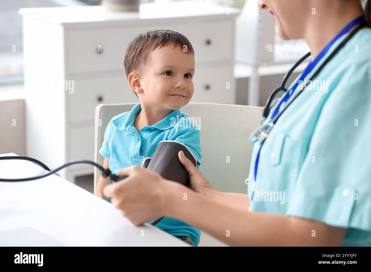 Female pediatrician with cute little boy measuring blood pressure in ...