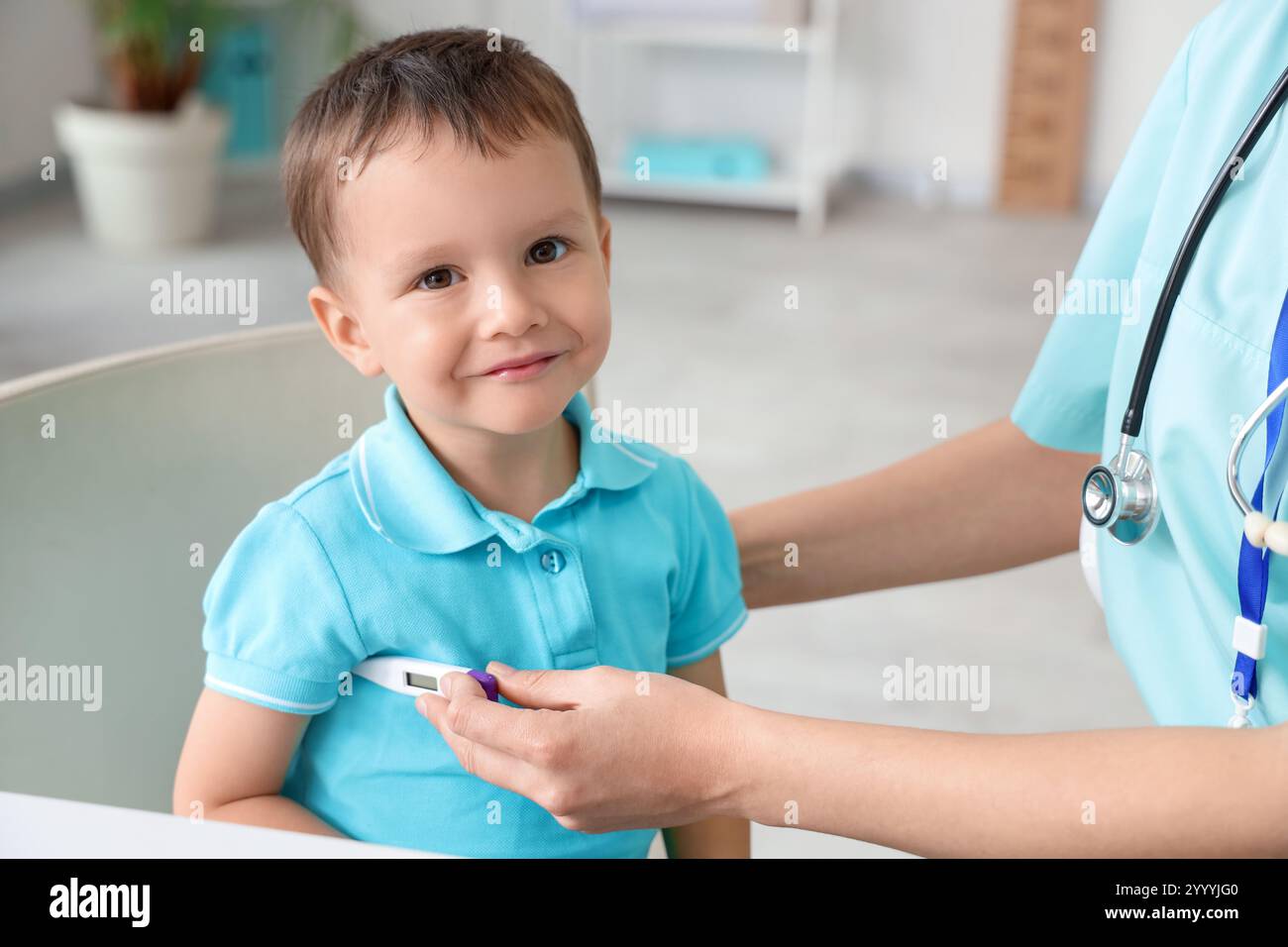 Female pediatrician measuring little boy's temperature in clinic ...