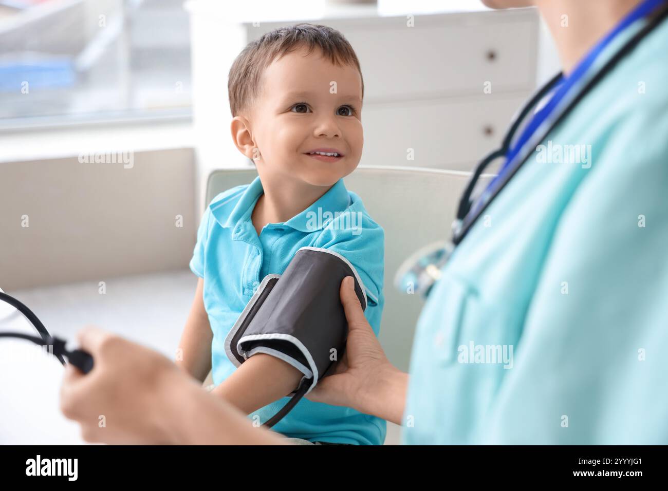 Female pediatrician with cute little boy measuring blood pressure in ...