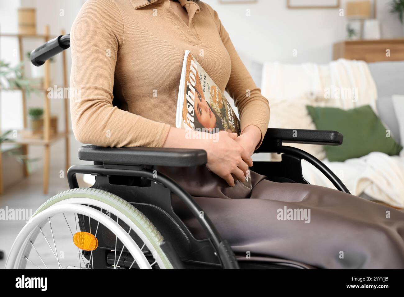 Young woman in wheelchair with fashion magazine at home Stock Photo - Alamy