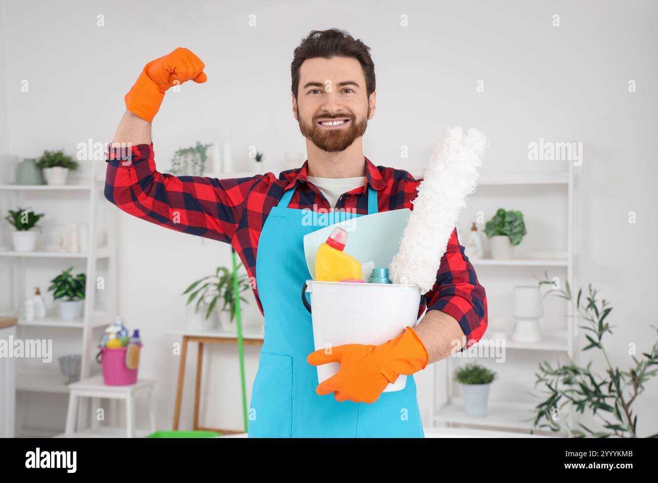 Male janitor with cleaning supplies showing muscles in bathroom Stock ...