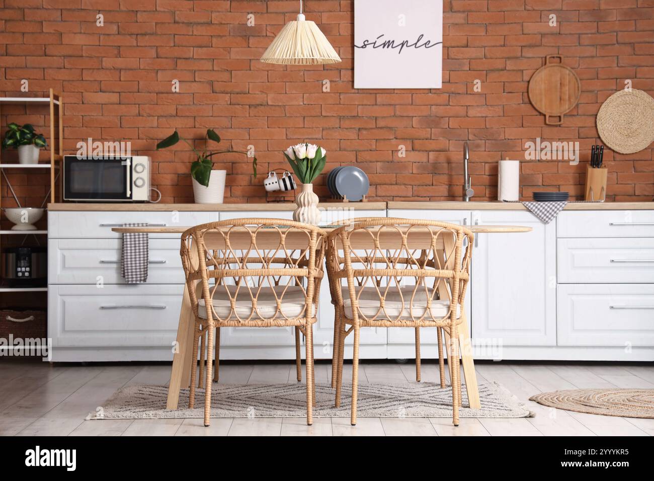 Interior of modern kitchen with counters, shelf unit and dining table ...