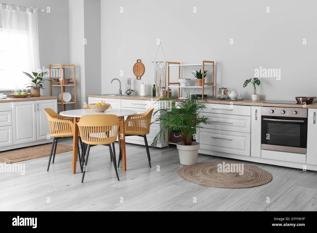 Interior of light kitchen with counters, shelf units and dining table ...