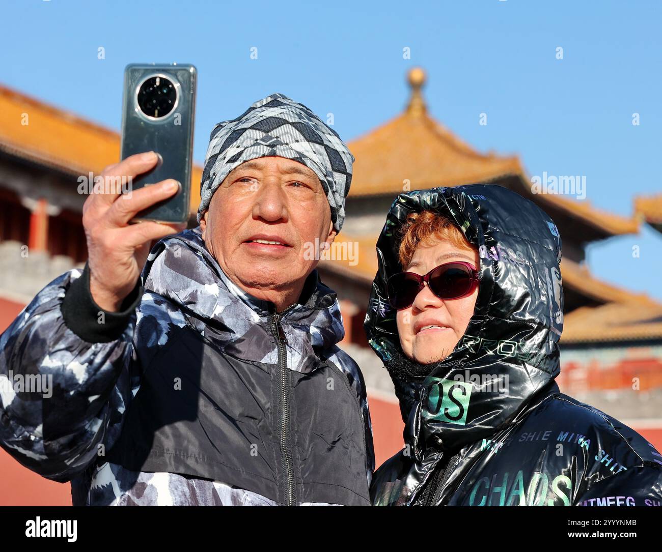 Tourists wearing thick clothes visit the Palace Museum in Beijing ...