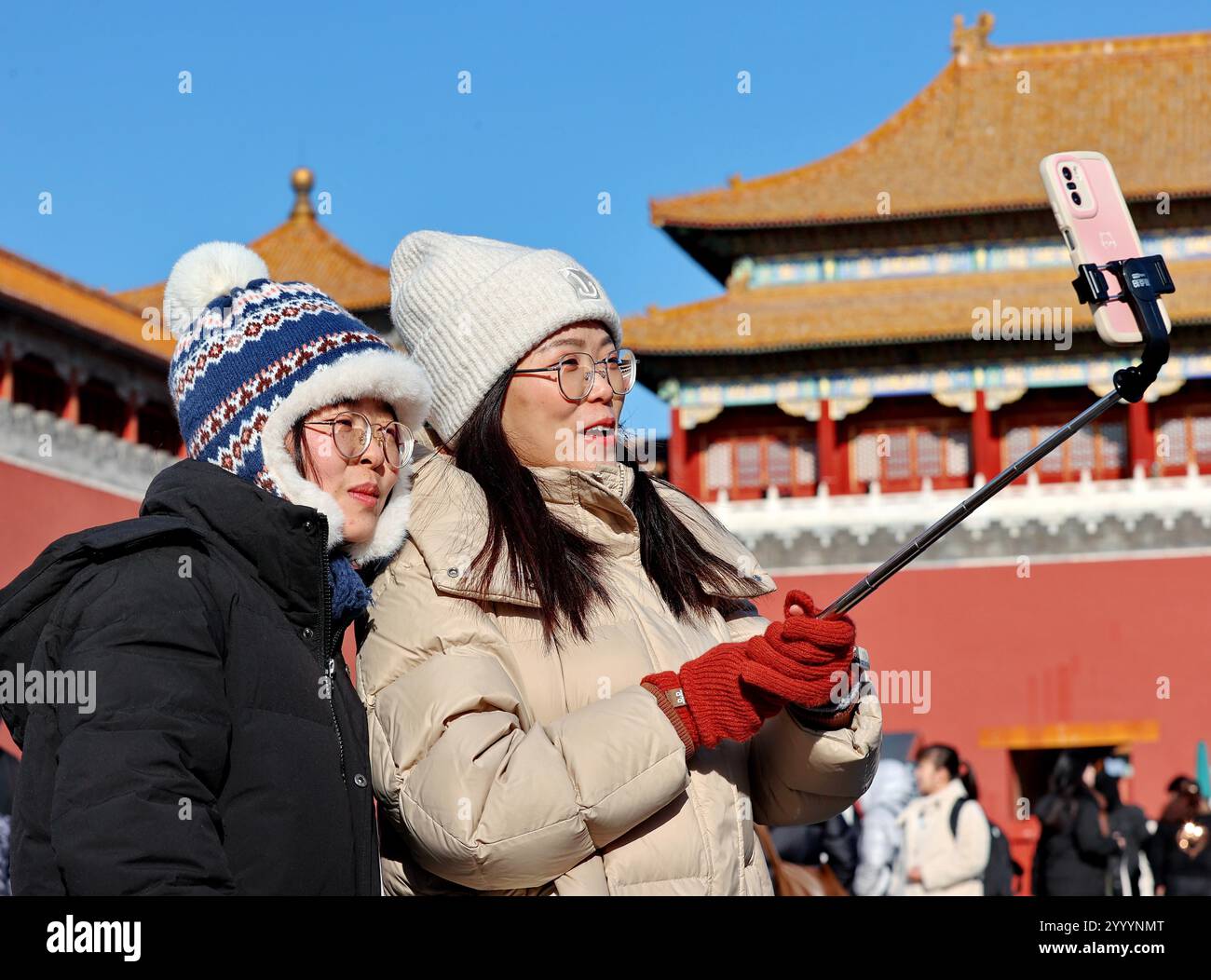 Tourists wearing thick clothes visit the Palace Museum in Beijing ...