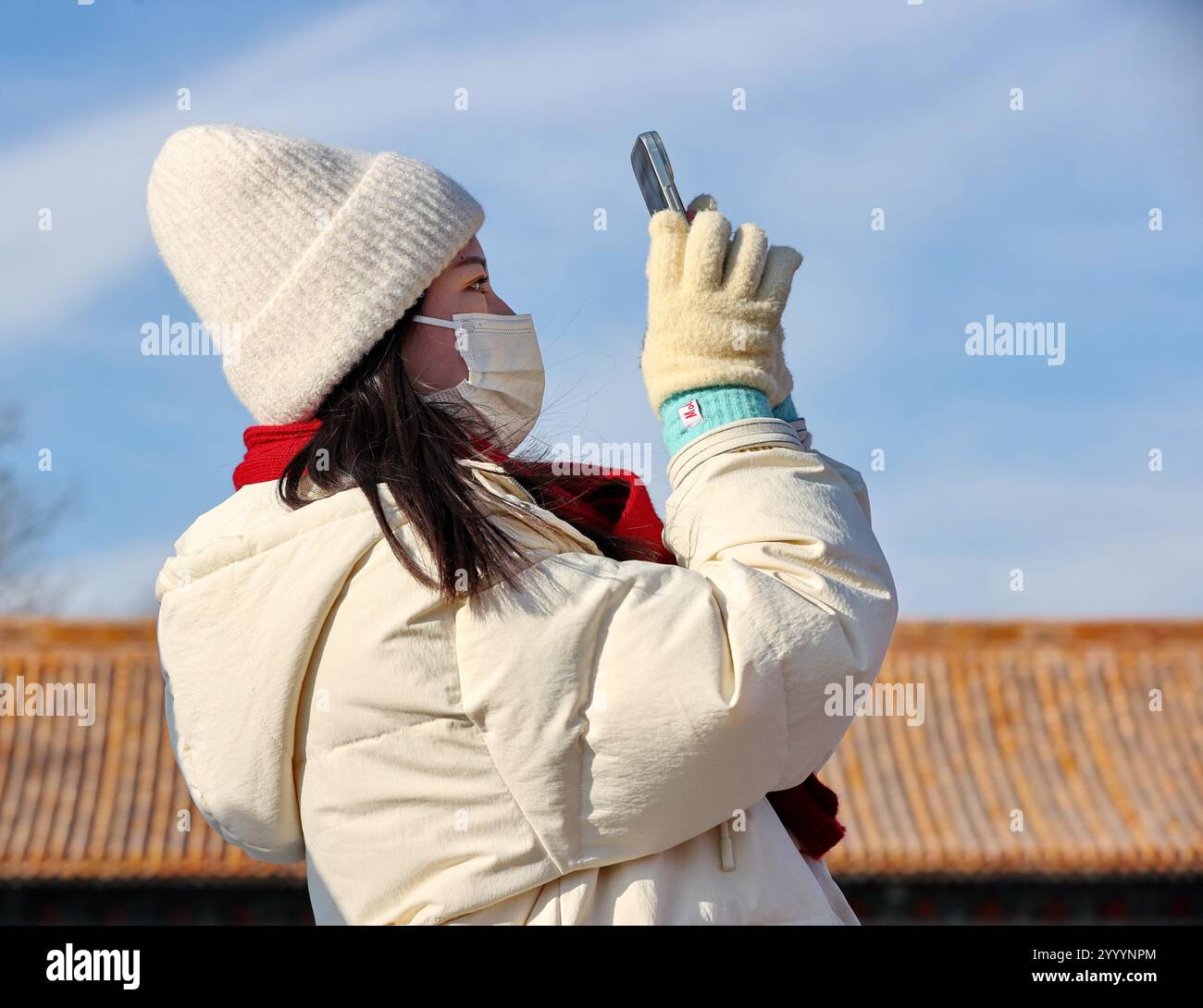 Tourists wearing thick clothes visit the Palace Museum in Beijing ...