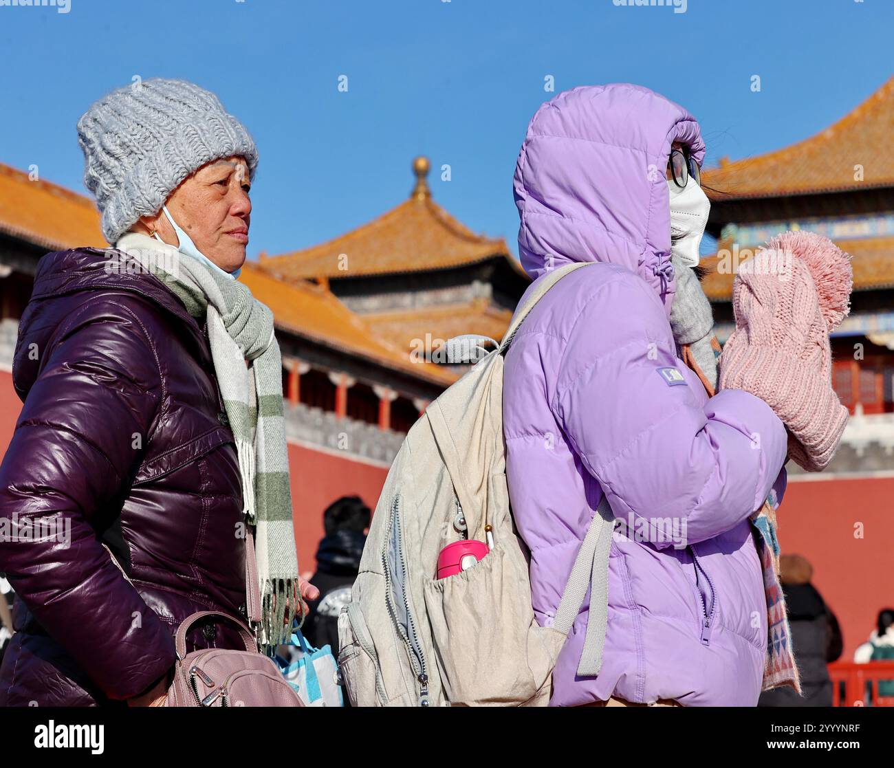 Tourists wearing thick clothes visit the Palace Museum in Beijing ...