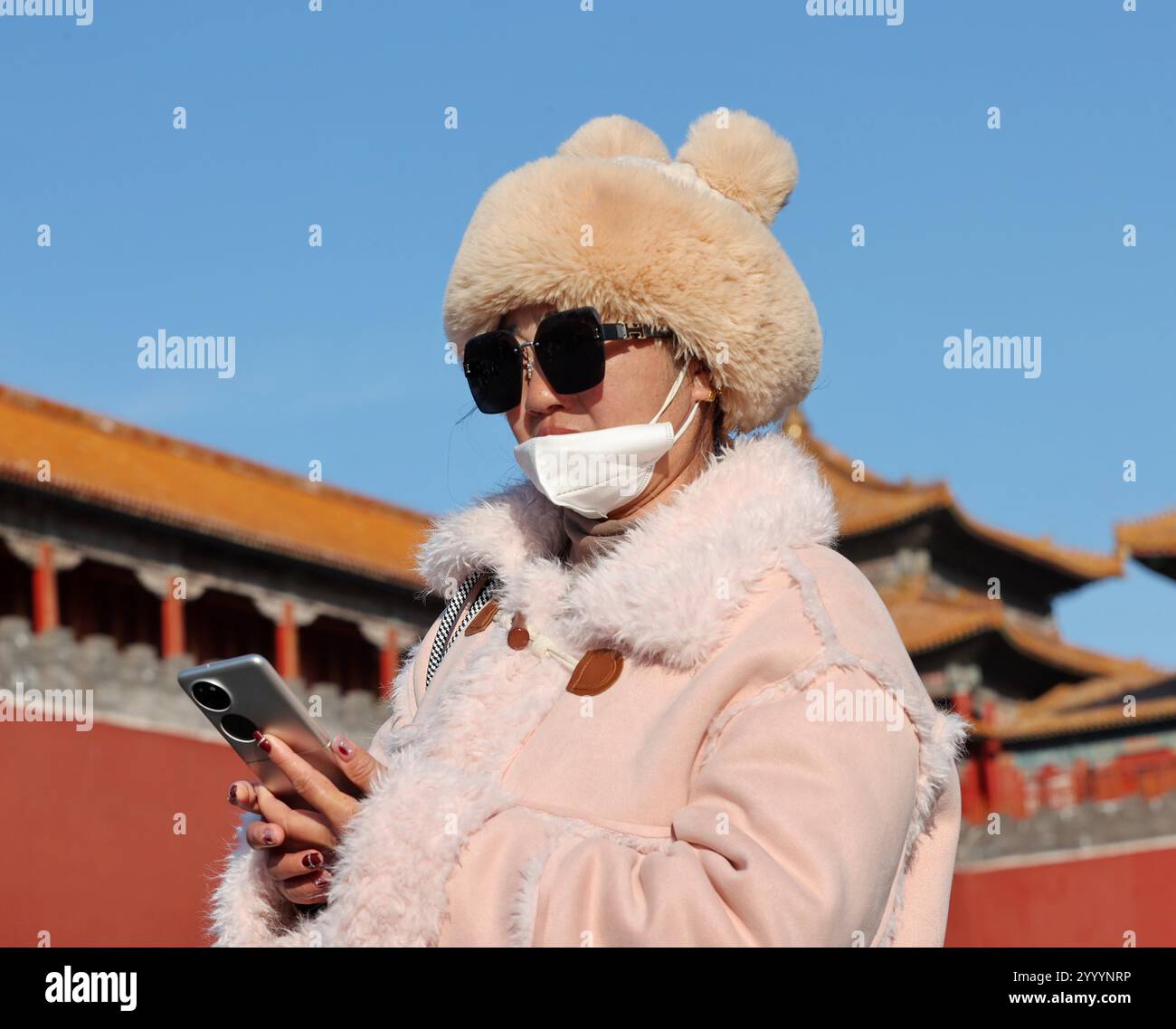 Tourists wearing thick clothes visit the Palace Museum in Beijing ...
