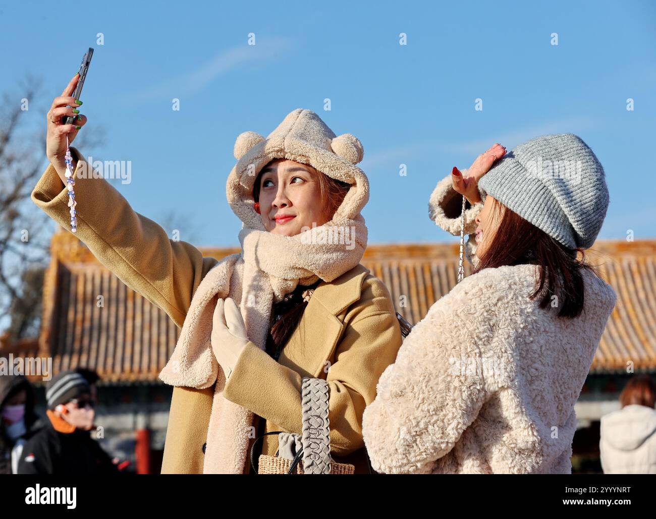 Tourists wearing thick clothes visit the Palace Museum in Beijing ...