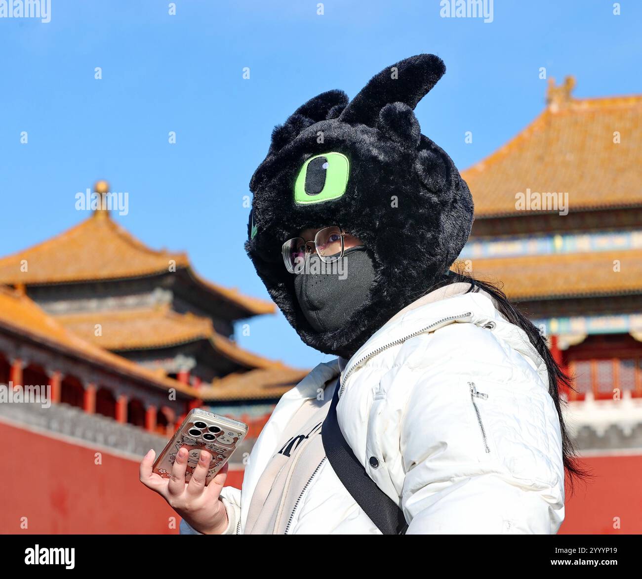 Tourists wearing thick clothes visit the Palace Museum in Beijing ...