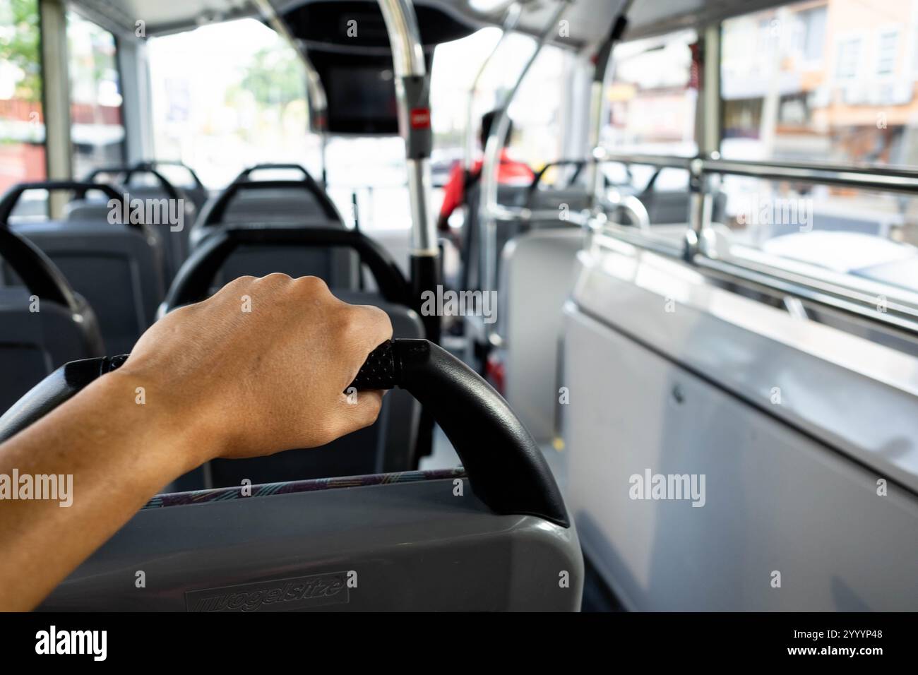A hand holding on to a seat inside a public bus in Malaysia Stock Photo ...
