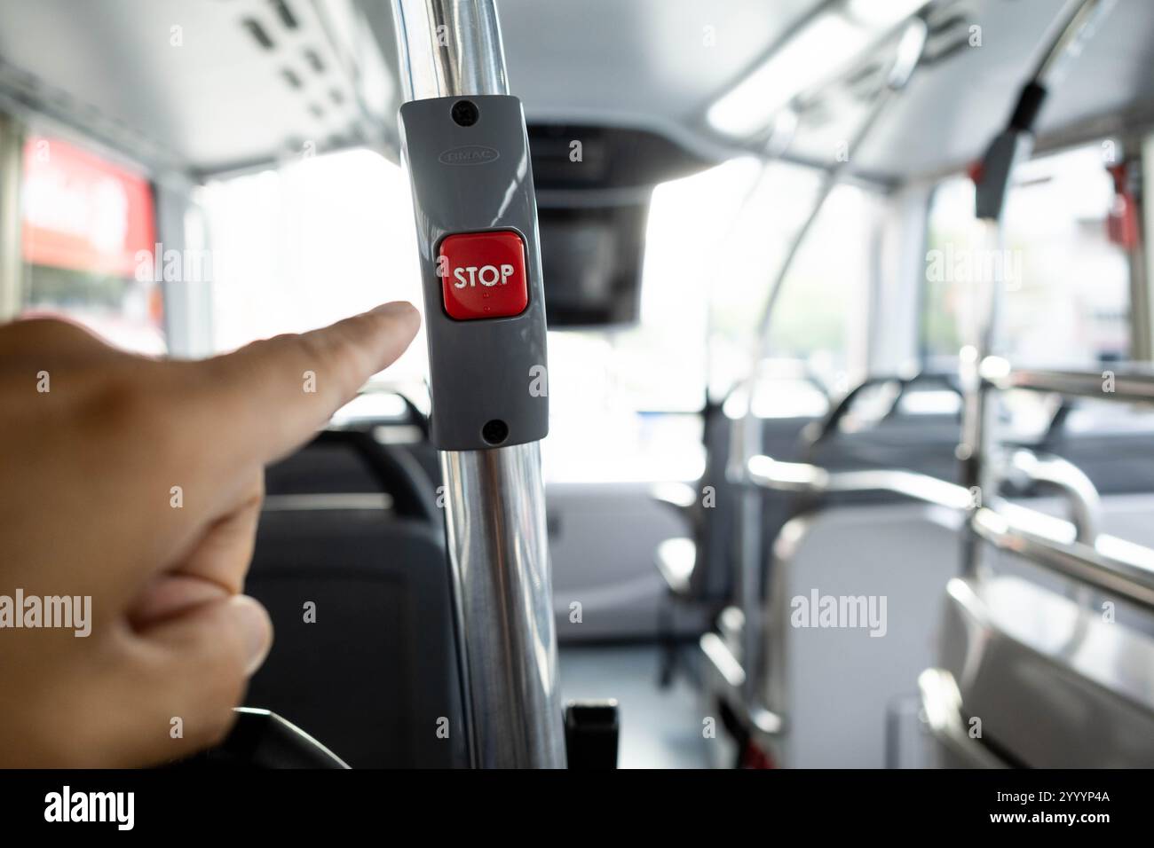 A hand pressing the Stop button inside a public bus Stock Photo - Alamy