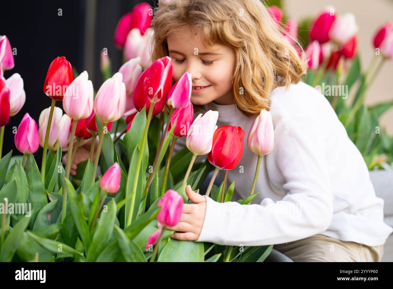 Tender Spring. Child play outdoors in a beautiful spring garden. Kid ...