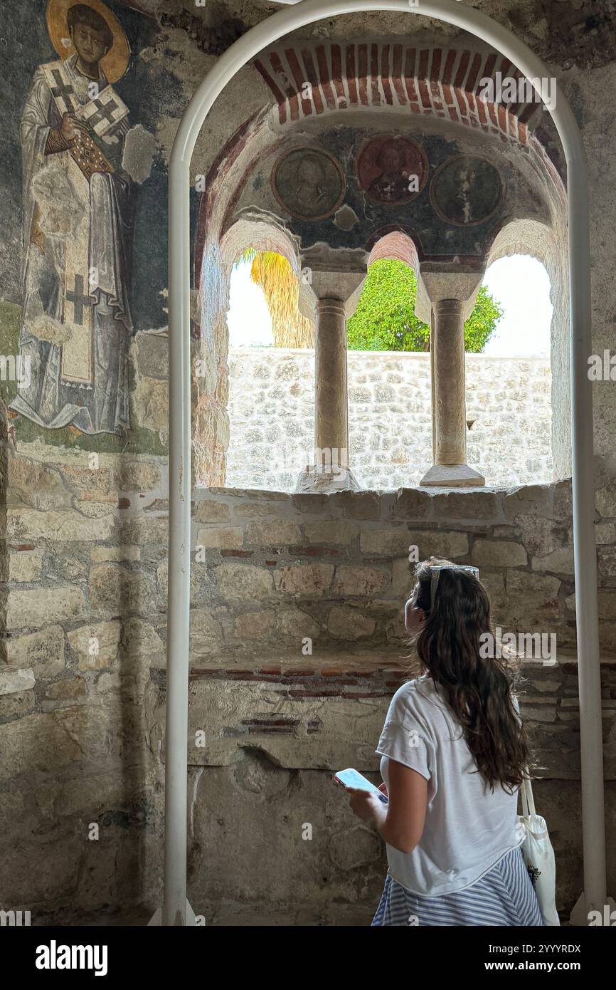 Back of tourist woman in ruins ancient medieval city old church Lycian ...