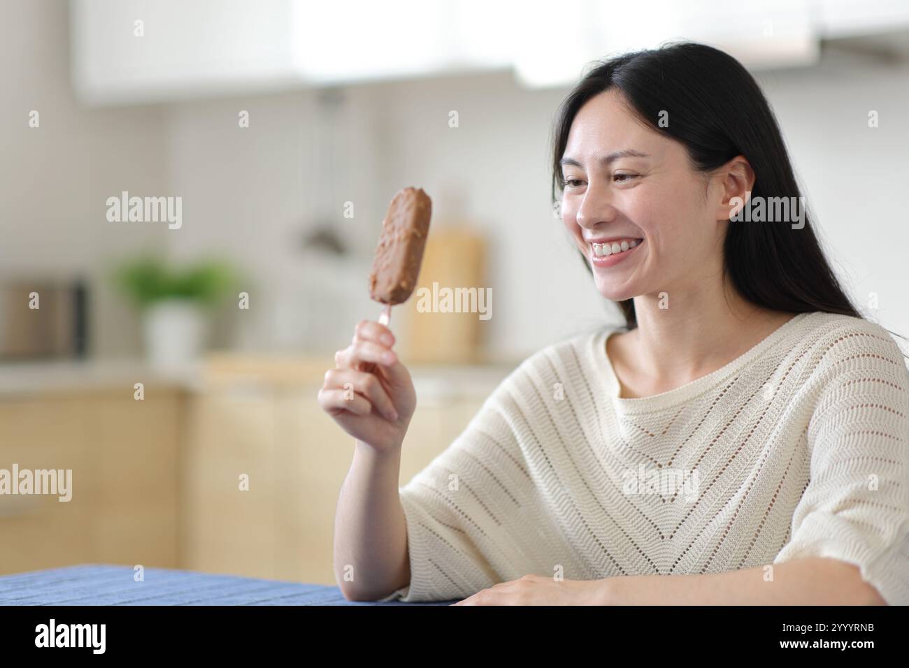 Happy asian woman looking at chocolate ice cream ready to eat it in the ...
