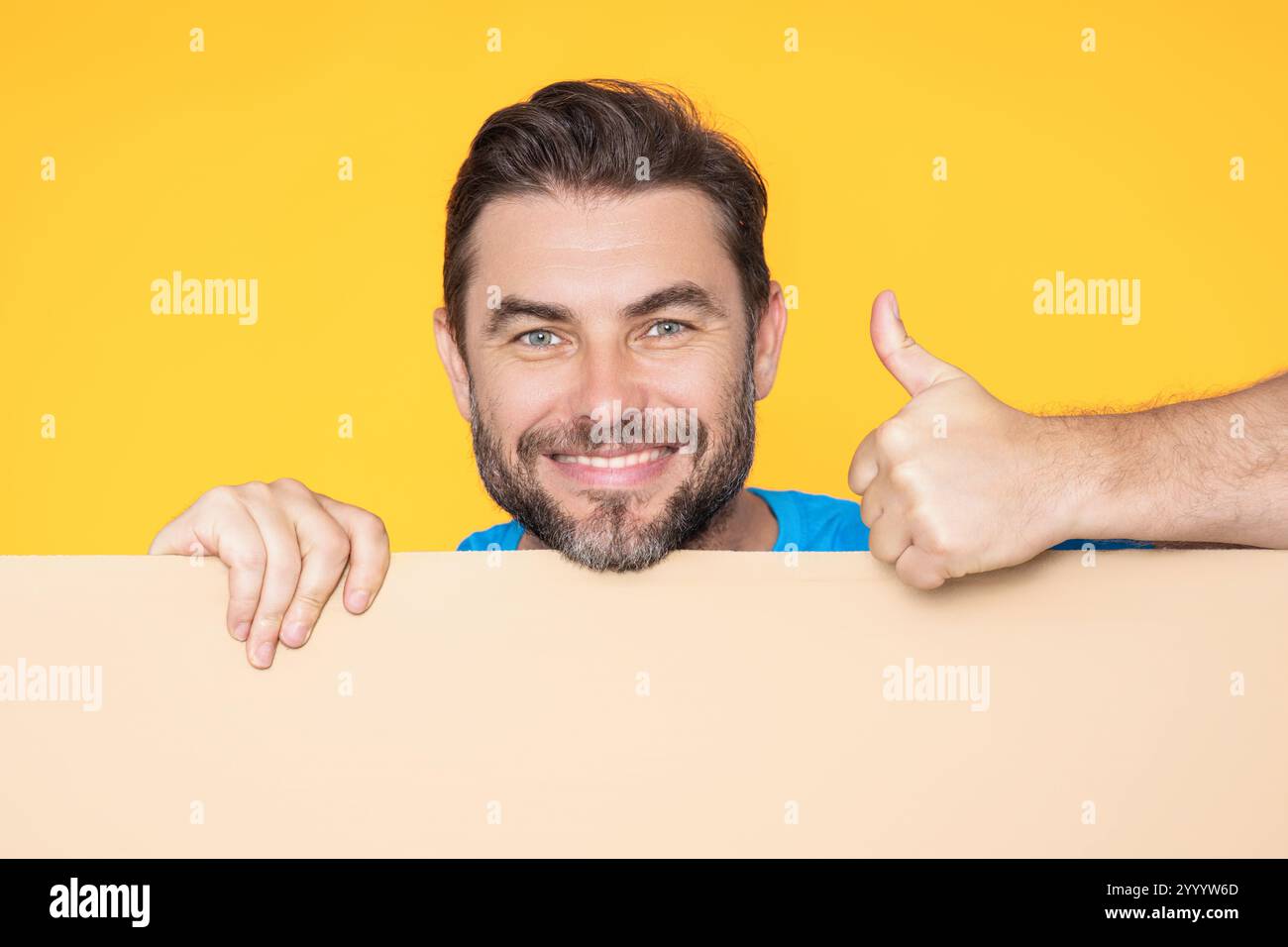 Man with thumb up and blank banner ad, on studio background. Portrait ...