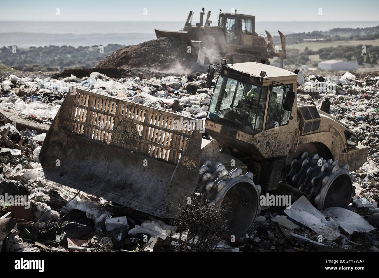 Heavy machinery shredding garbage in an open air landfill. Waste Stock ...