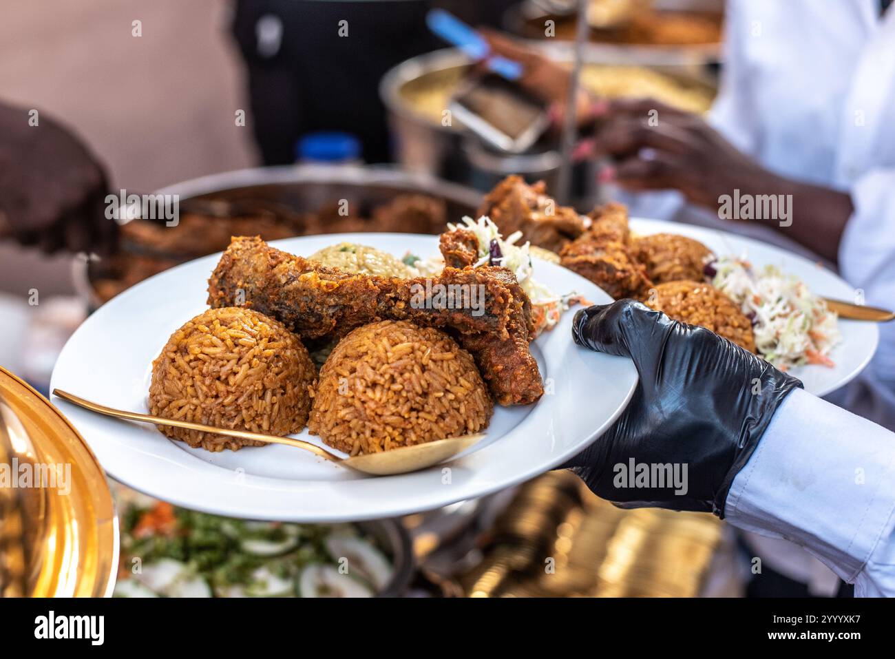Delighting in tradition, a waiter serves a feast of rice and fish at a ...