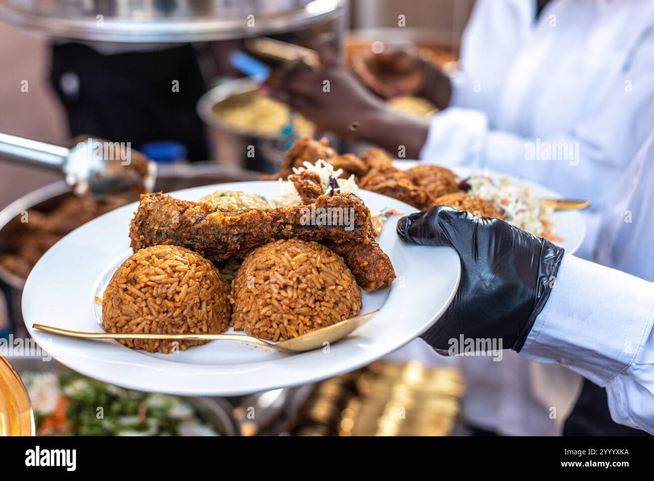 Delighting in tradition, a waiter serves a feast of rice and fish at a ...