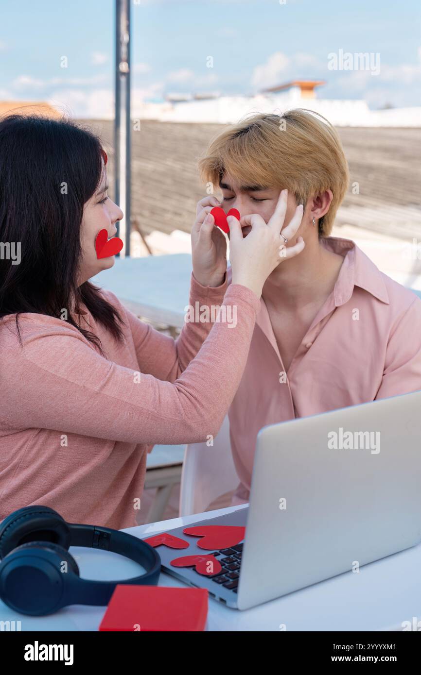 Couple celebrates valentine's day with playful gestures at beachside ...
