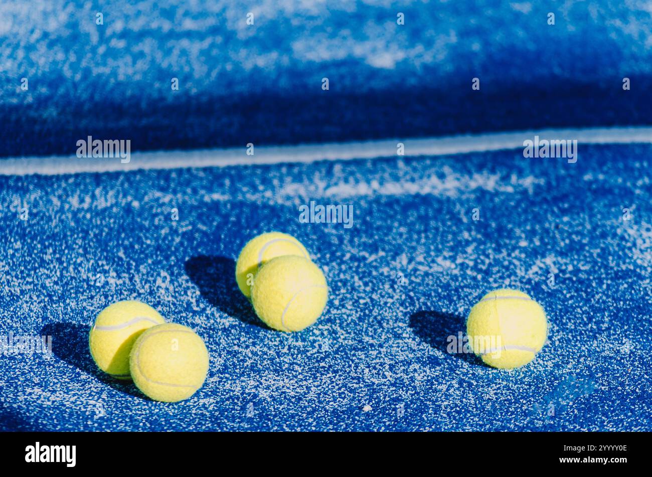 five balls ina a blue paddle tennis court Stock Photo - Alamy