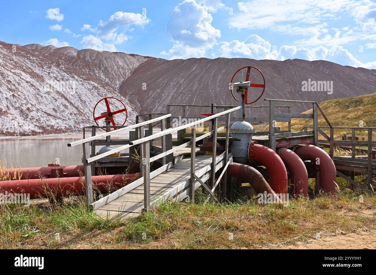 Industrial landscape with pipes on the background of slag hills in the ...