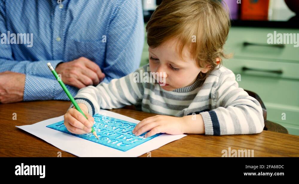 Father Teaching Son How To Write Using Stencil Stock Video Footage - Alamy