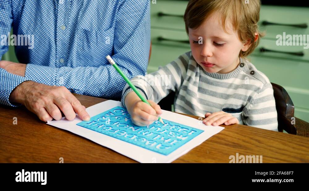 Father Teaching Son How To Write Using Stencil Stock Video Footage - Alamy