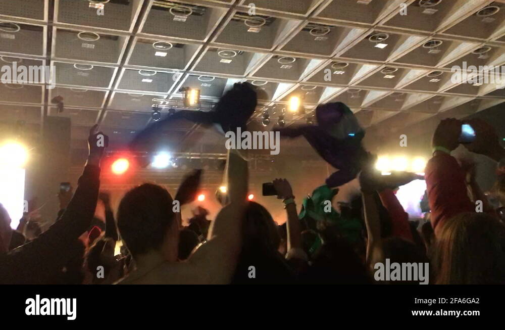 People in a club or at concert waving T-shirts and jumping crowd of ...