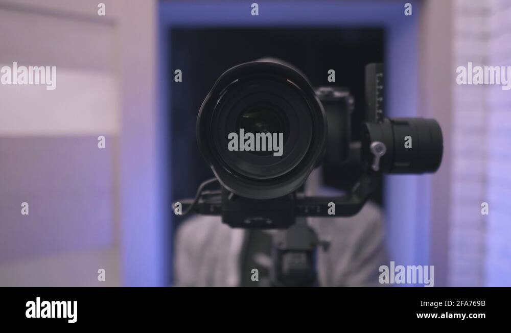 Filmmaker operates handheld gimbal with camera. 4K UHD cinematic ...