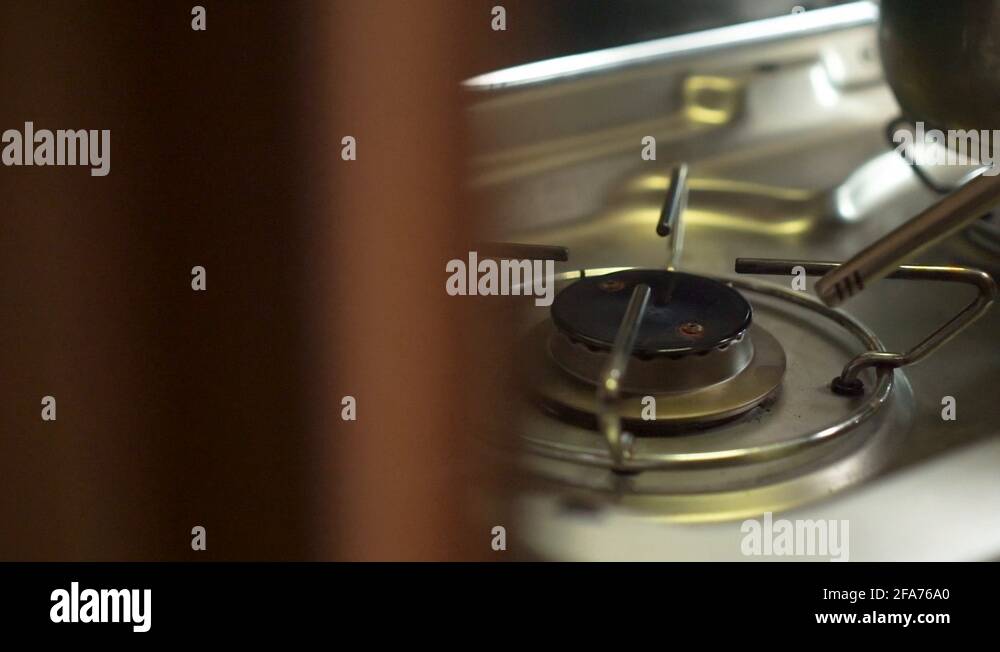 Close up - Lighting up gas stover burner fire and a pot in a campervan ...