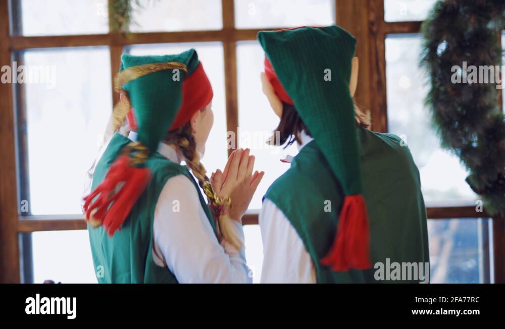 Funny elves with long ears are looking out the window in anticipation ...