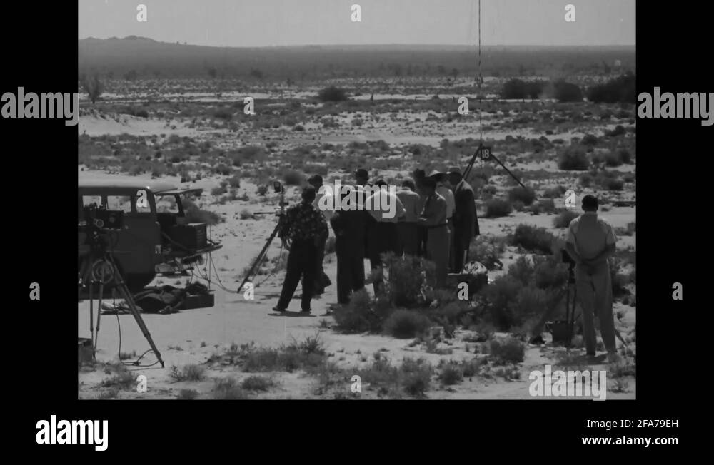 Cameraman setup tracking station in desert terrain and helicopter ...
