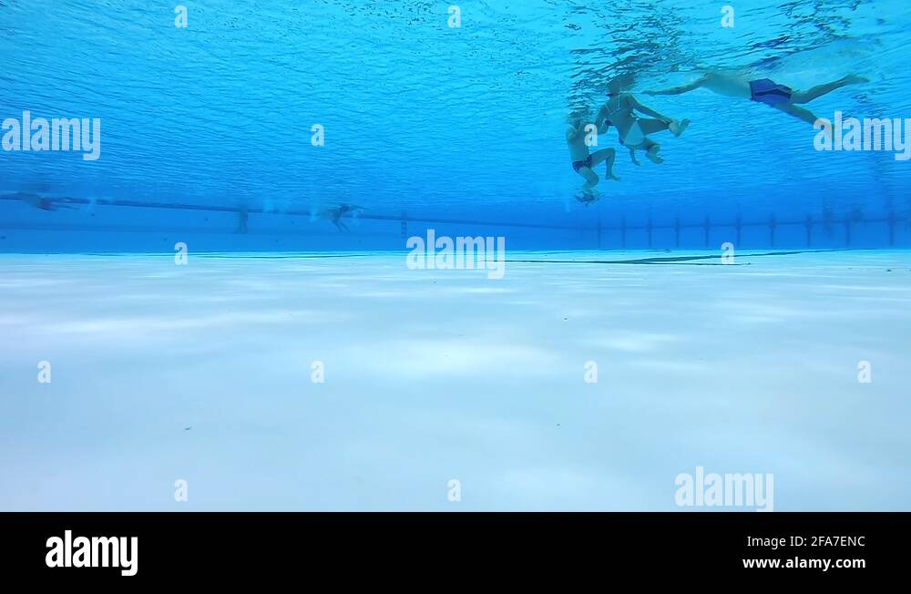 Swimming in the pool. Underwater shoot of swimming pool with people ...