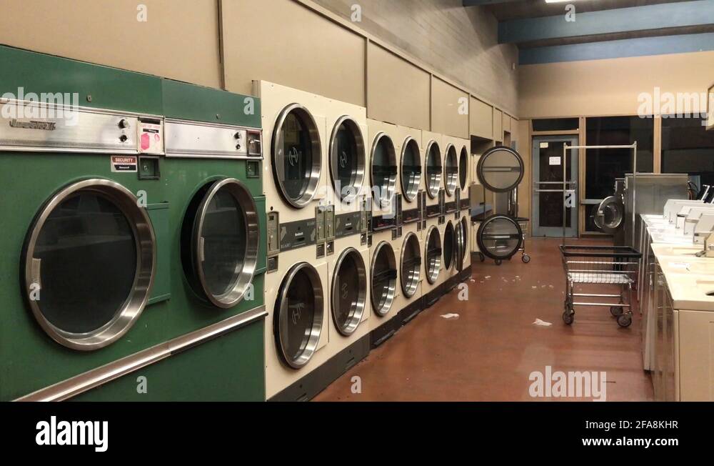 4k UHD handheld footage of a clean, brightly lit, empty Laundromat shot ...