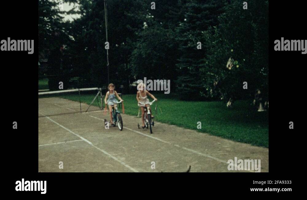 1950s: Tennis court. Little girls ride bikes. Girls shake hands. Women ...