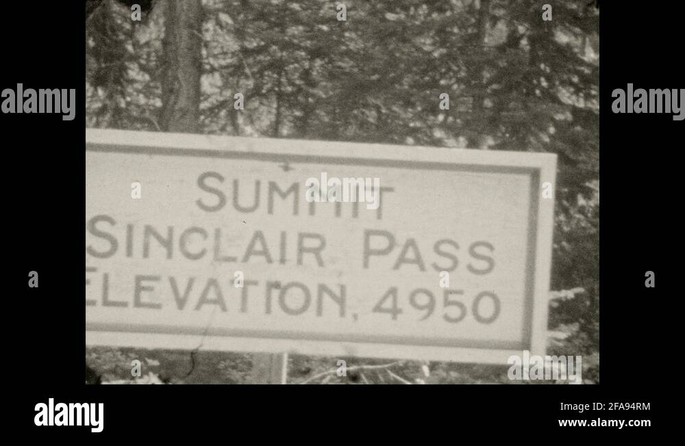 1920s: Sign that says "Summit Sinclair Pass: Elevation, 4950." Girl peeks out of Stock Video ...