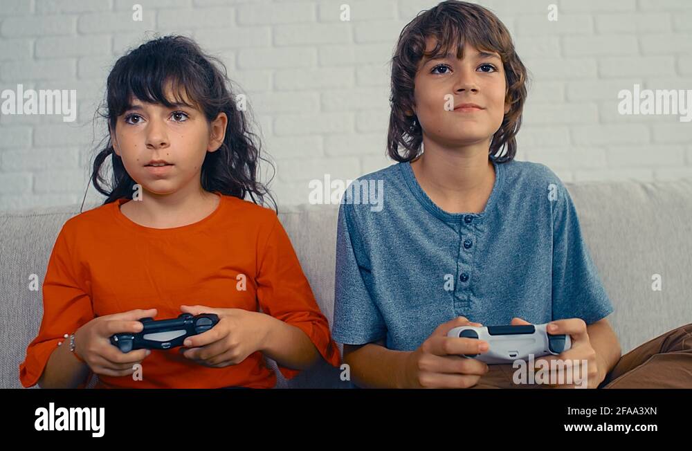 Boy and girl playing video game console, have fun, laugh, hold the ...